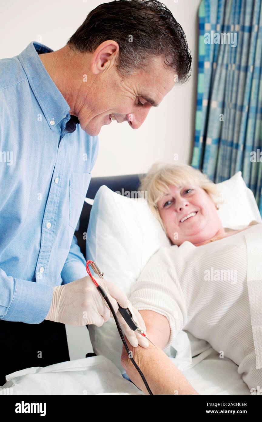 Diathermy. Doctor using diathermy on a patient in a hospital. Diathermy ...