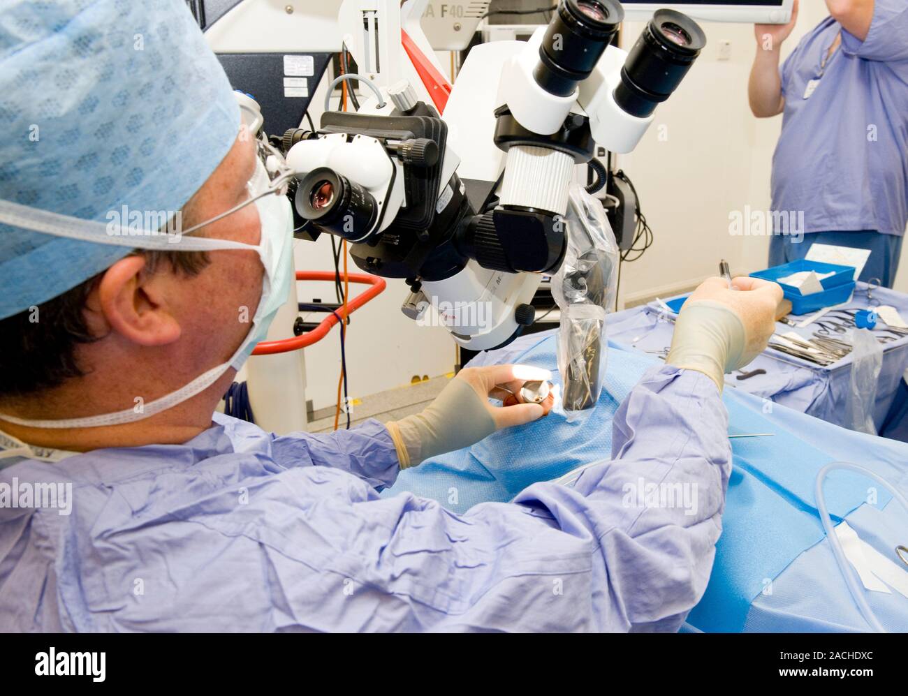 Middle ear surgery. Surgeon using a microscope while operating on a ...