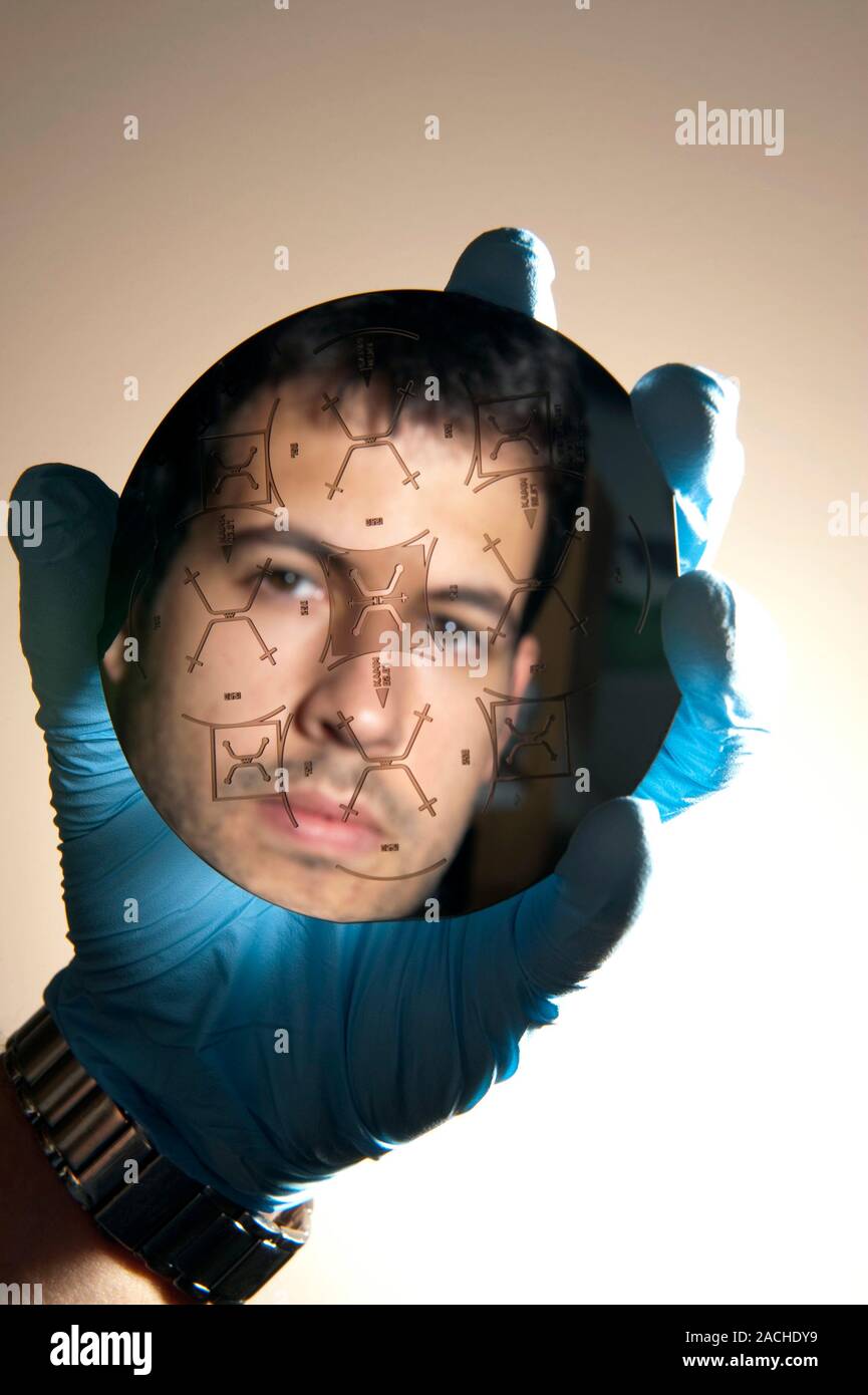 Lab-on-a-chip. Researcher holding a silicon lab-on-a-chip designed for ...