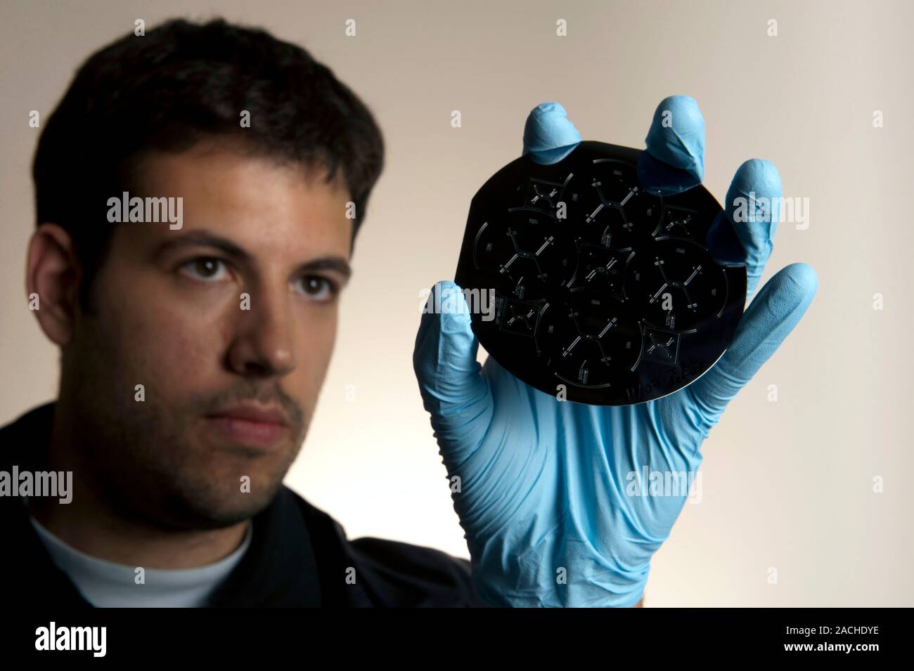 Lab-on-a-chip. Researcher holding a silicon lab-on-a-chip designed for ...