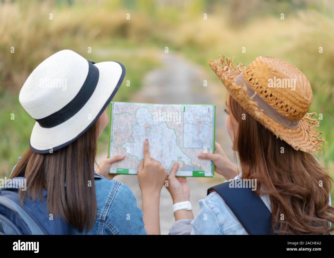 two woman traveler searching direction on location map while traveling ...