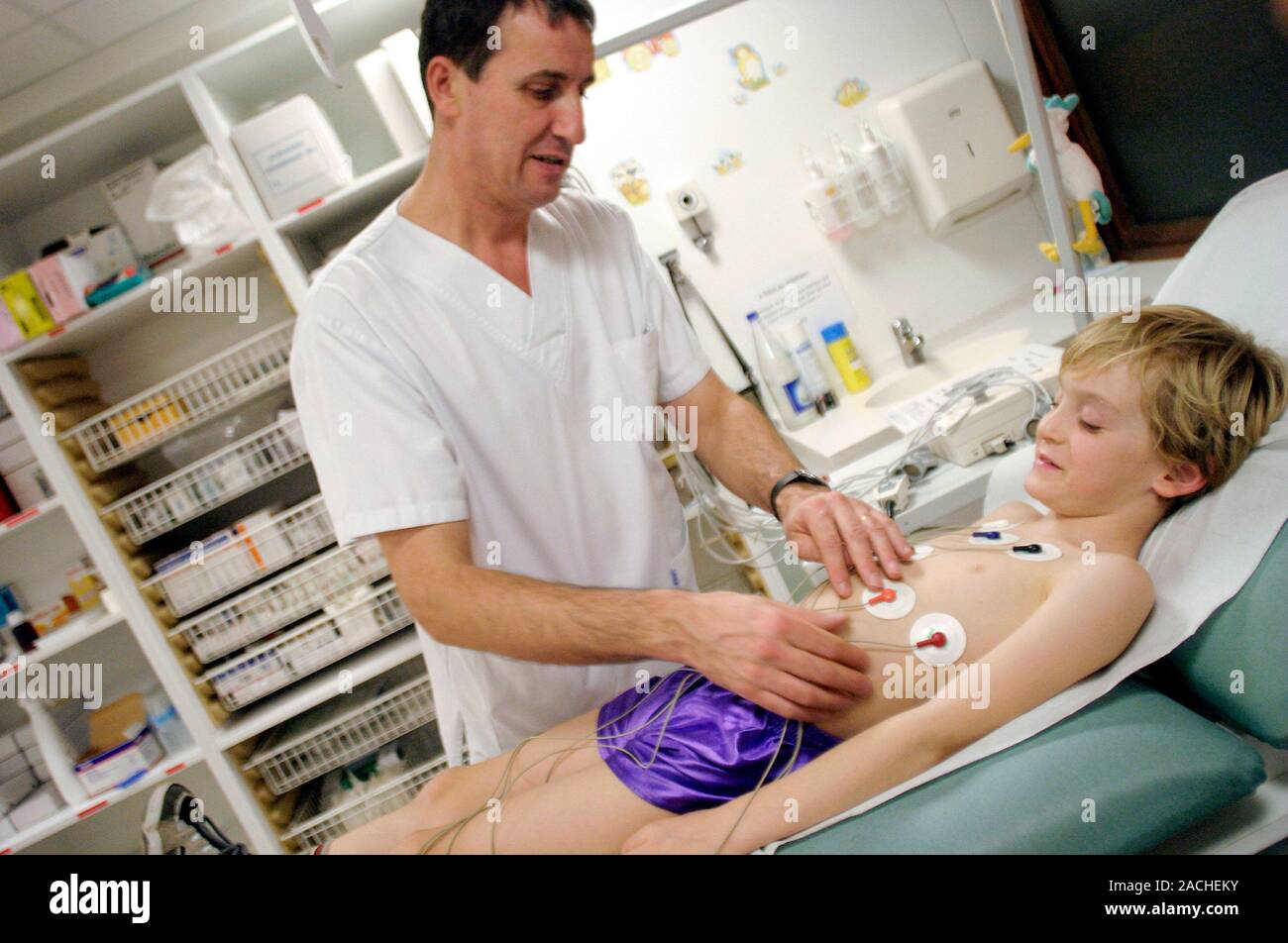 Paediatric heart monitoring. Boy undergoing an electrocardiography (ECG ...