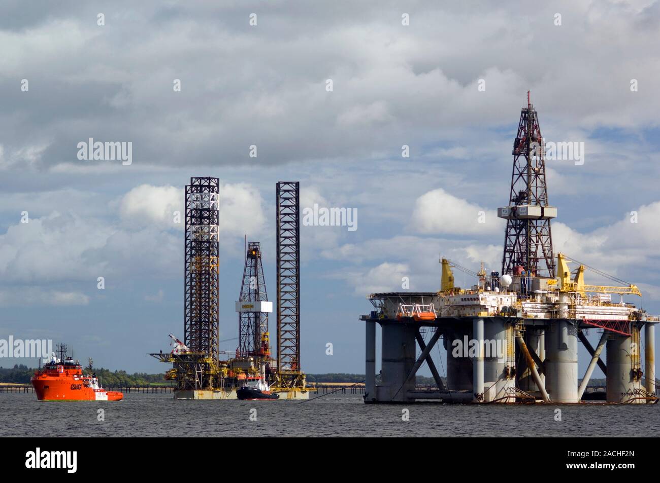 Oil drilling rigs. Ensco 80 jackup oil rig (left) being towed past the ...
