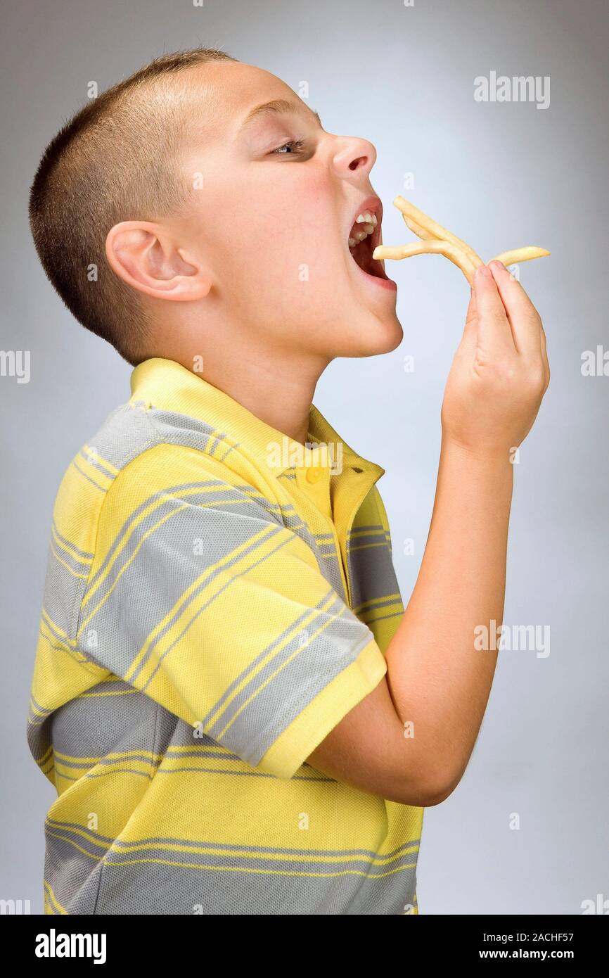 Boy eating french fries Stock Photo - Alamy