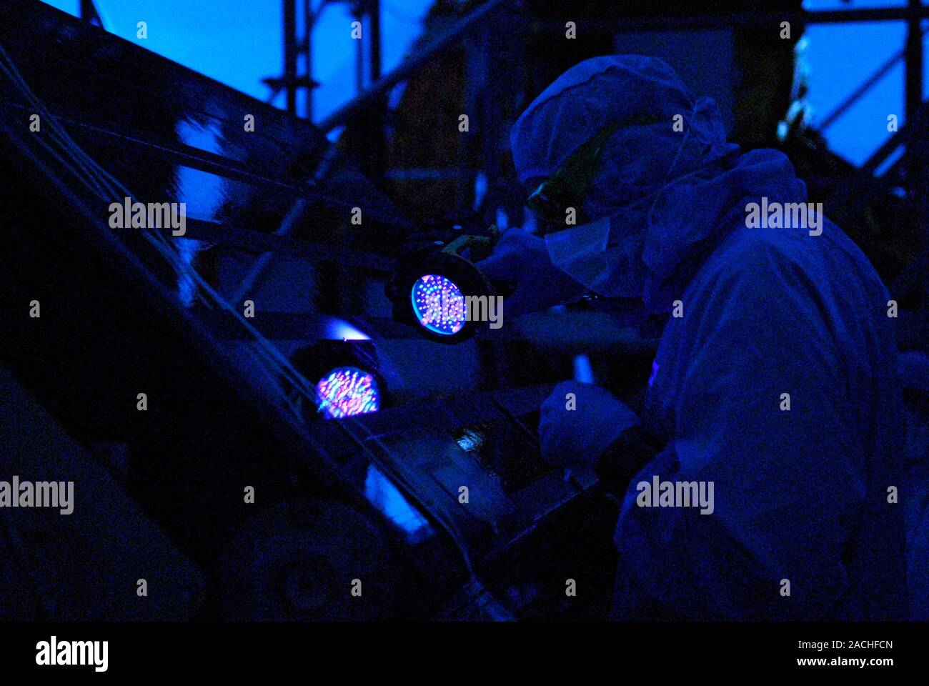 Cosmic Origins Spectrograph inspection. Clean room worker inspecting ...