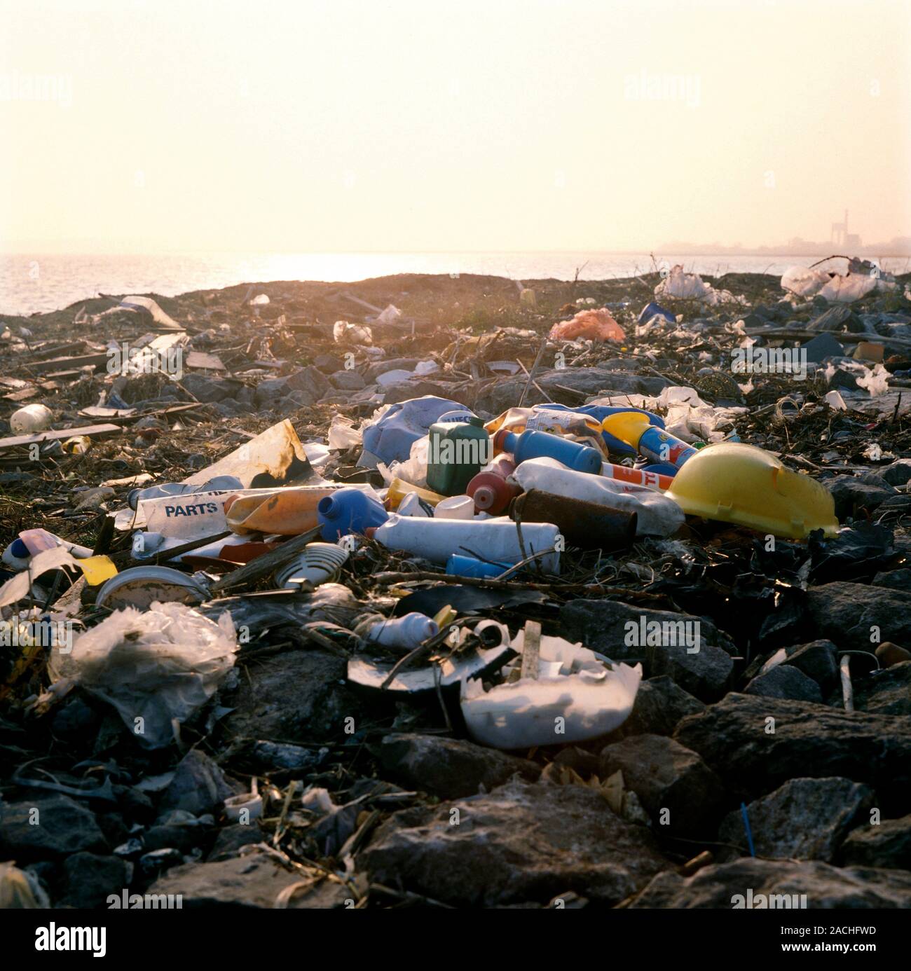 Washed-up rubbish. Plastic waste washed up on a riverbank. Photographed ...