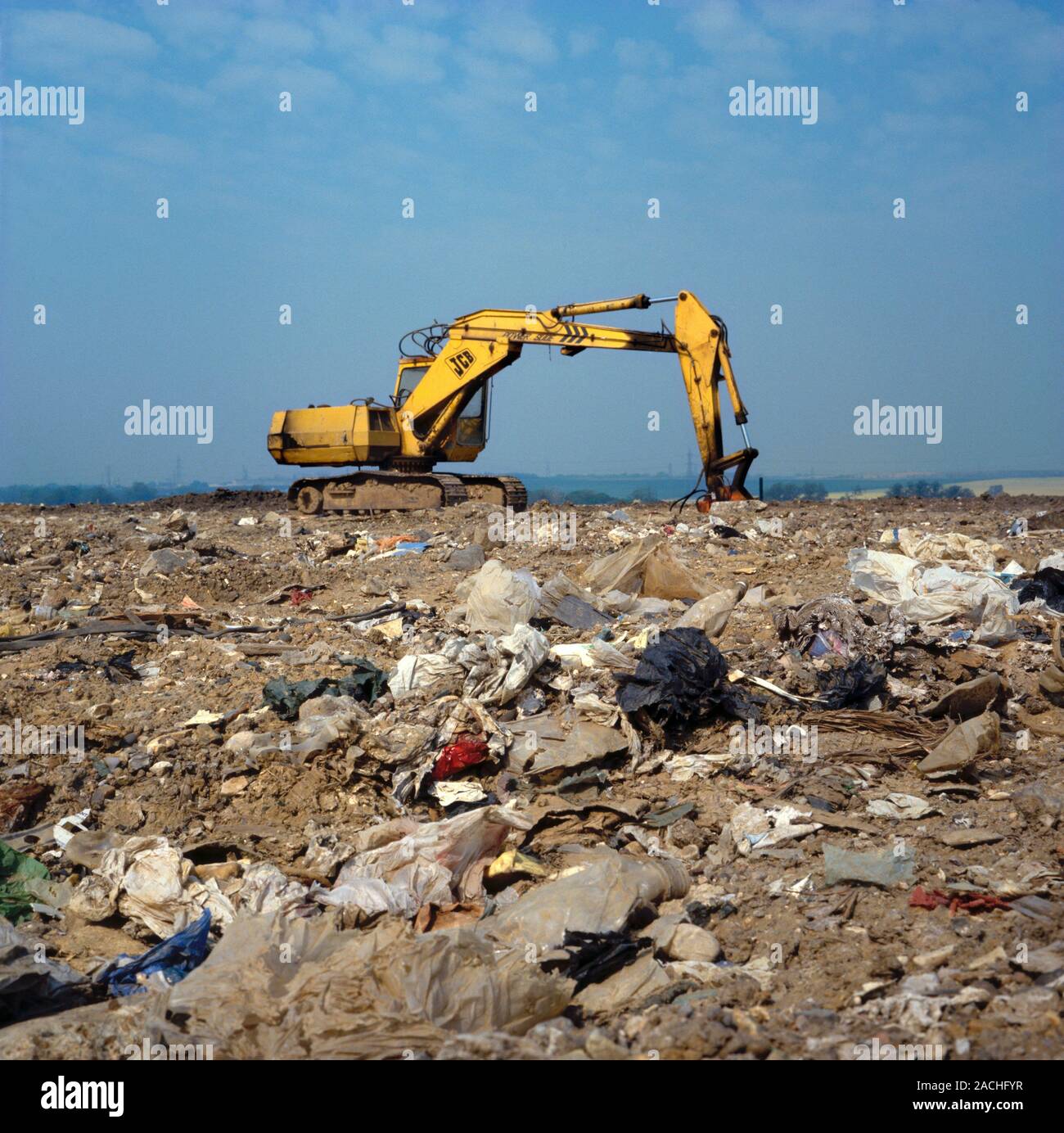 Landfill site. Digger moving waste at a landfill site. Photographed in ...