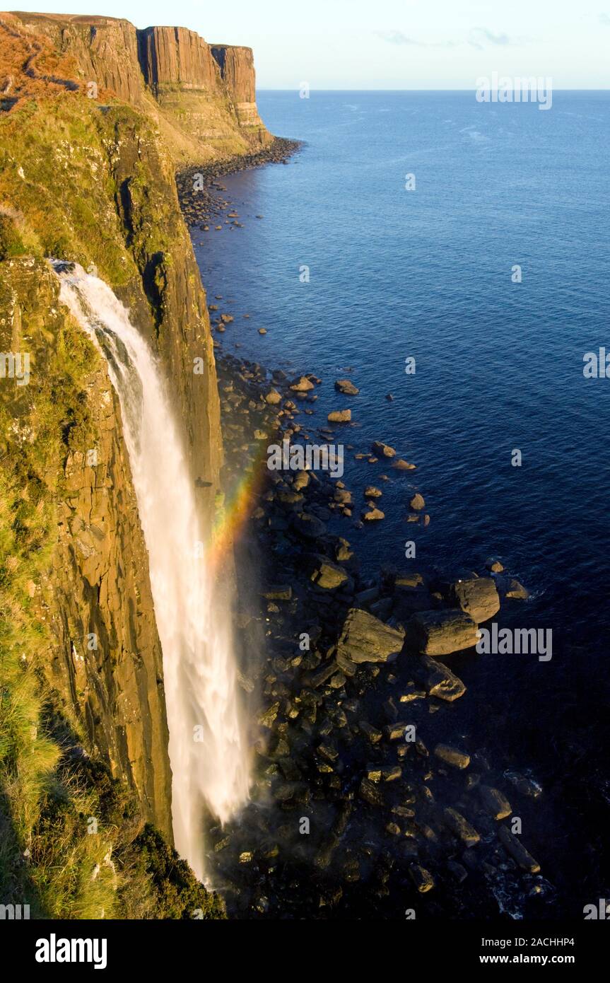 Coastal waterfall, with a partial rainbow seen in the spray. The water ...
