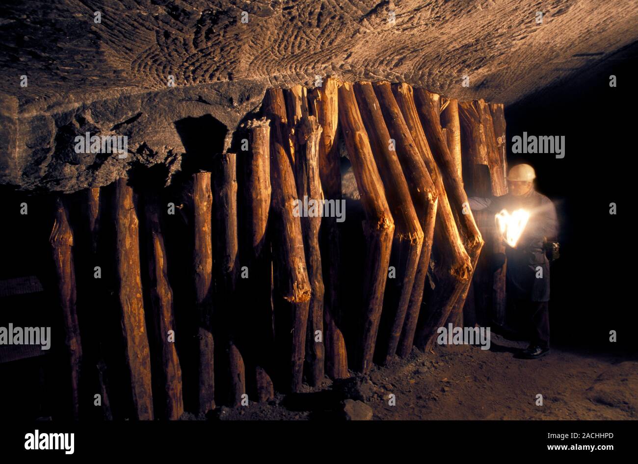 Wooden support beams being inspected by a miner, Wieliczka Salt Mine ...
