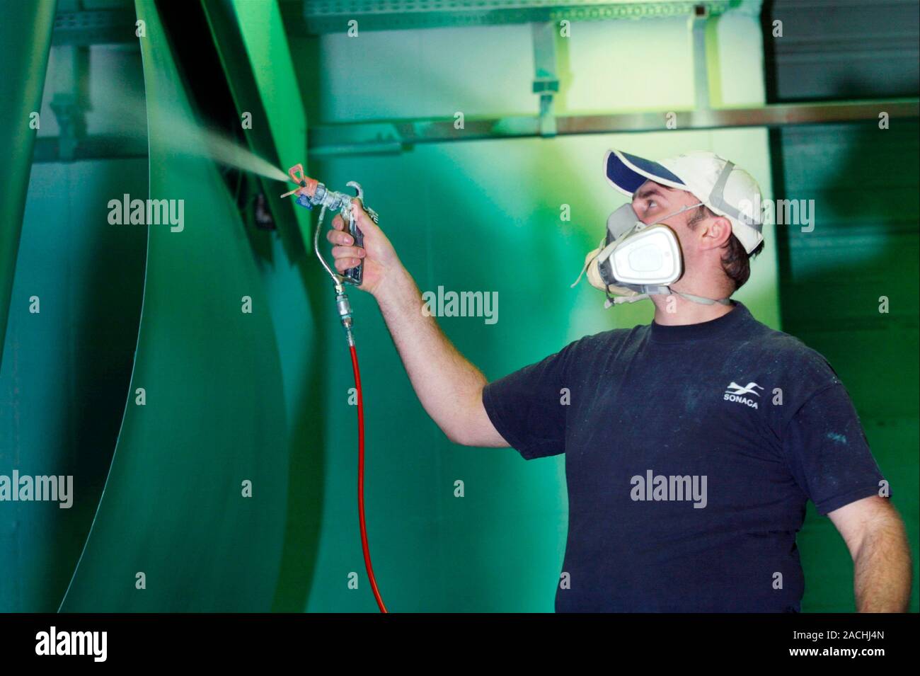 Aeroplane spray painting. Worker using a spray painting device in an ...
