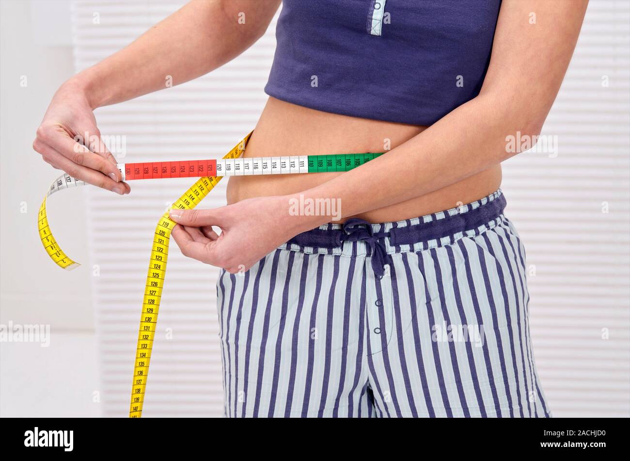 Waist size measurement being carried out by a woman using a tape ...