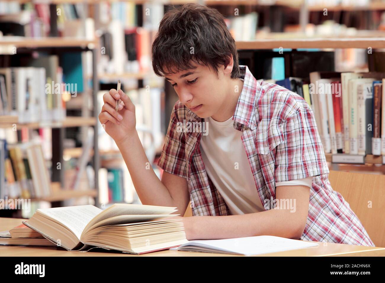 Library. Young man studying in a library Stock Photo - Alamy