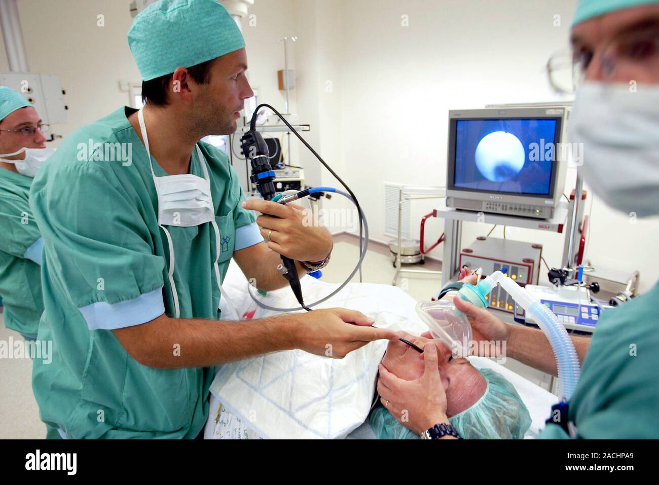 Diagnosing cancer. Doctors using a fibroscope to investigate suspected ...