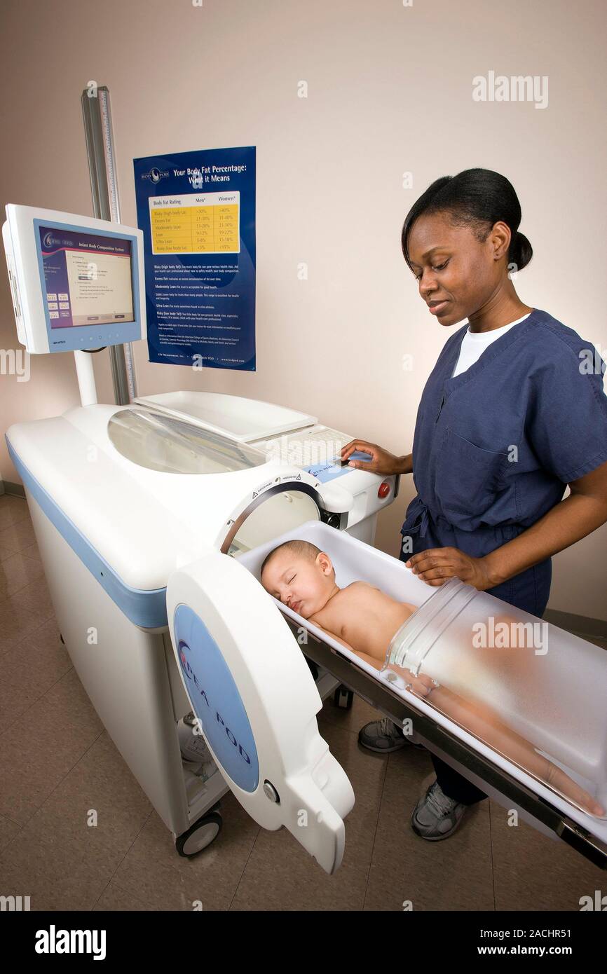 Childhood body fat research. Researcher using a machine, known as the ...