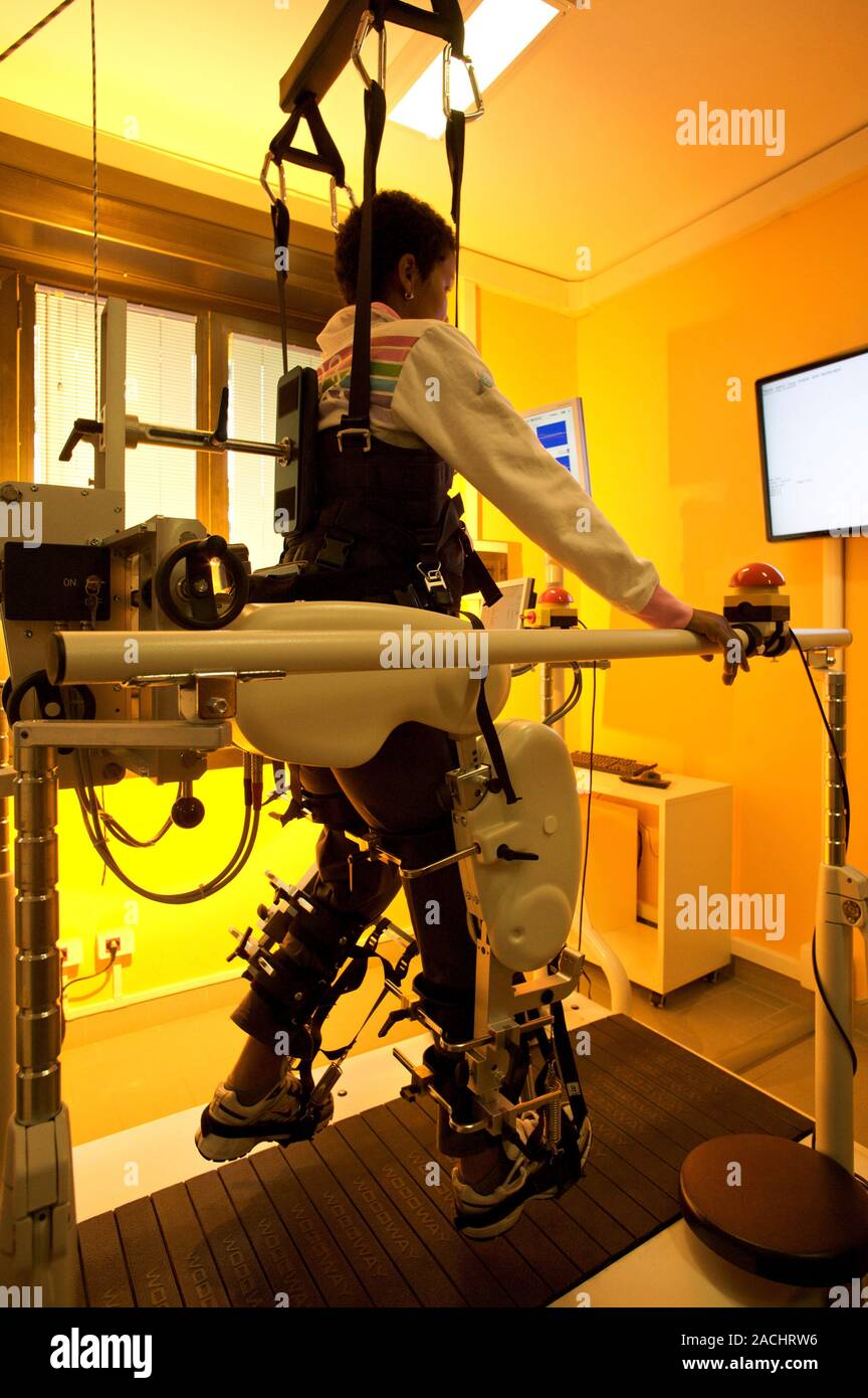 Lokomat walking therapy. Female patient on a treadmill, using the ...