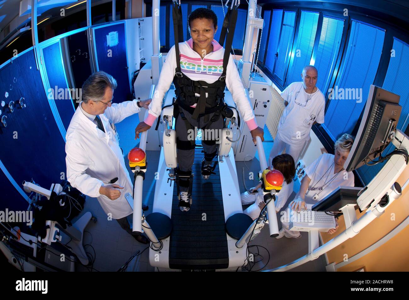 Lokomat walking therapy. Doctor watching a female patient on a ...