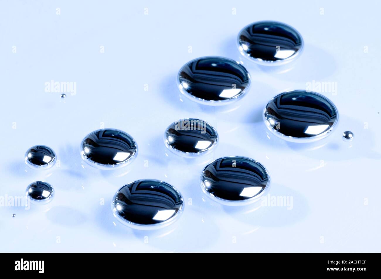 Drops of liquid mercury on a hard surface. Mercury has a very low ...