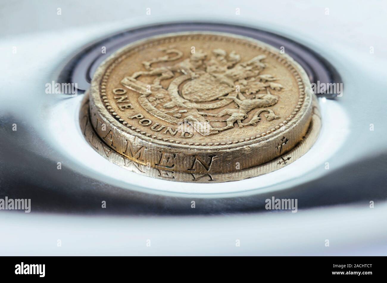 One pound coin floating on liquid mercury. Mercury has a very low ...