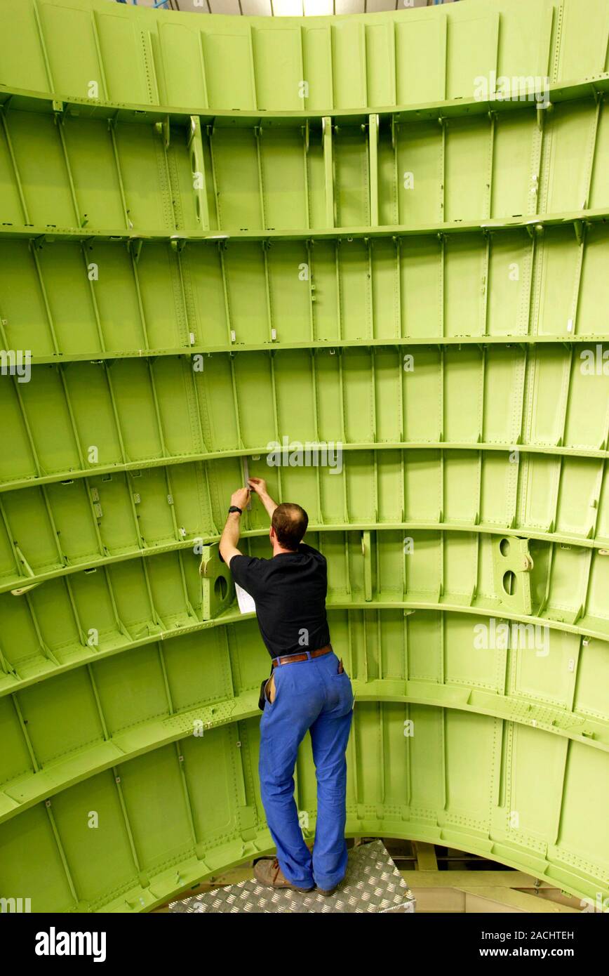 Aerospace engineering. Worker inspecting a structure being built in an ...