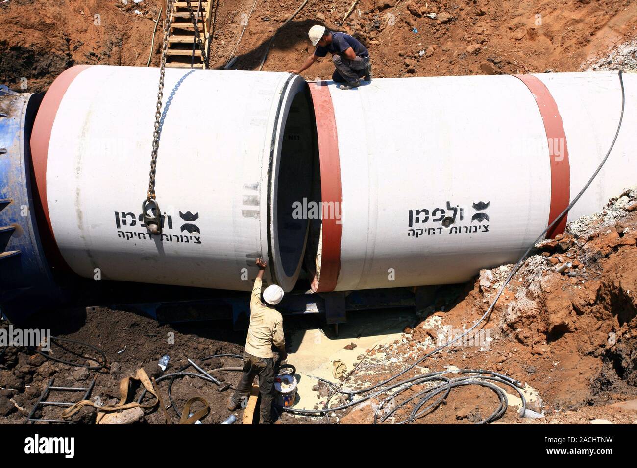 Sewer construction. Engineers putting new sewage pipes in place ...