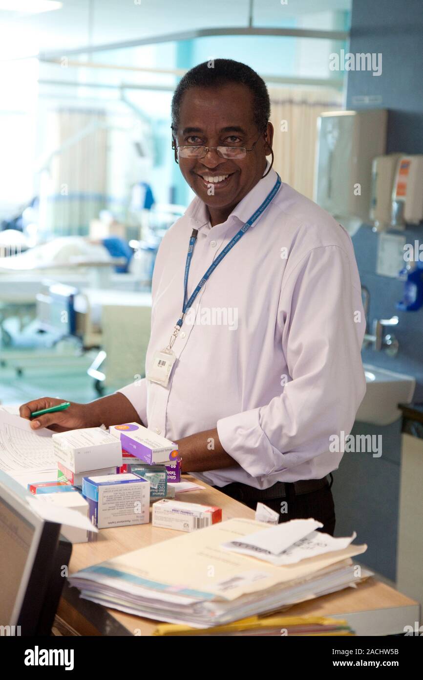 Hospital staff. Pharmacist checking patients' drug charts on a ward ...