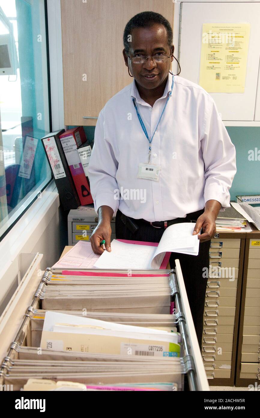 Hospital staff. Pharmacist checking patient notes on a ward ...