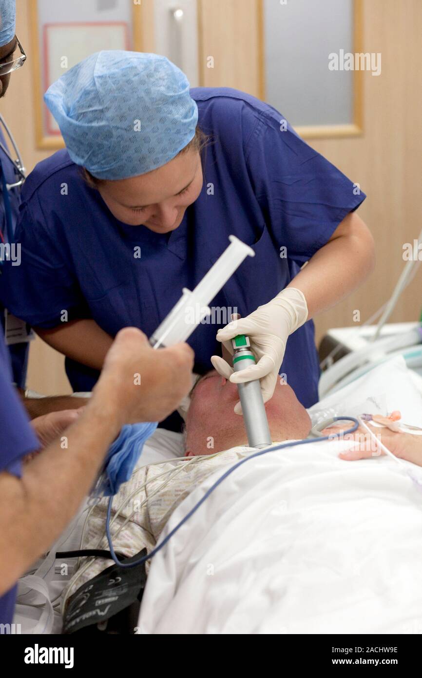 Intubating a patient. Doctor inserting a breathing tube into a patient ...