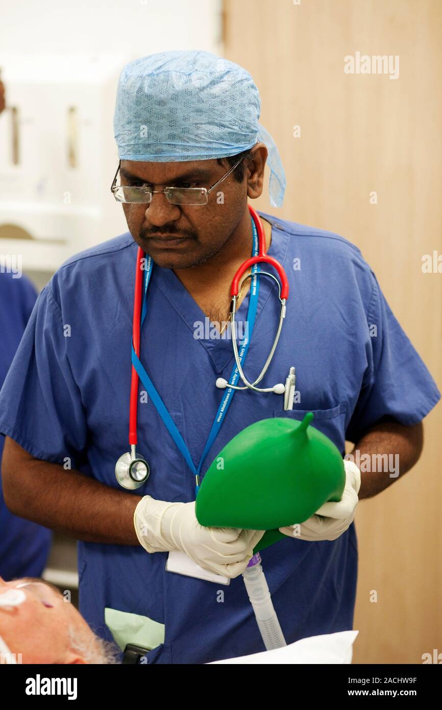 Patient ventilation. Anaesthetist squeezing a balloon to help ventilate ...