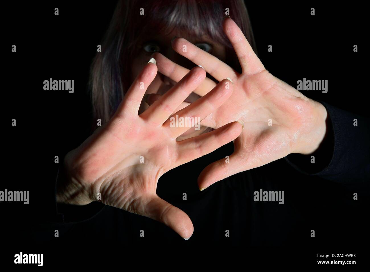 Frightened woman shielding her face with her hands Stock Photo - Alamy