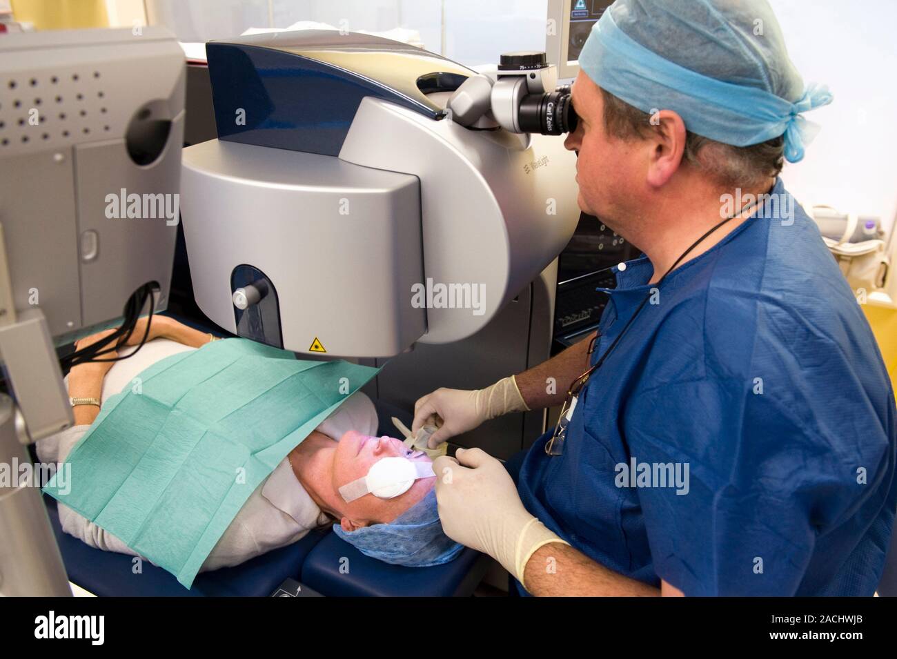 Laser eye surgery. Ophthalmic surgeon checking a patient's eyes after ...