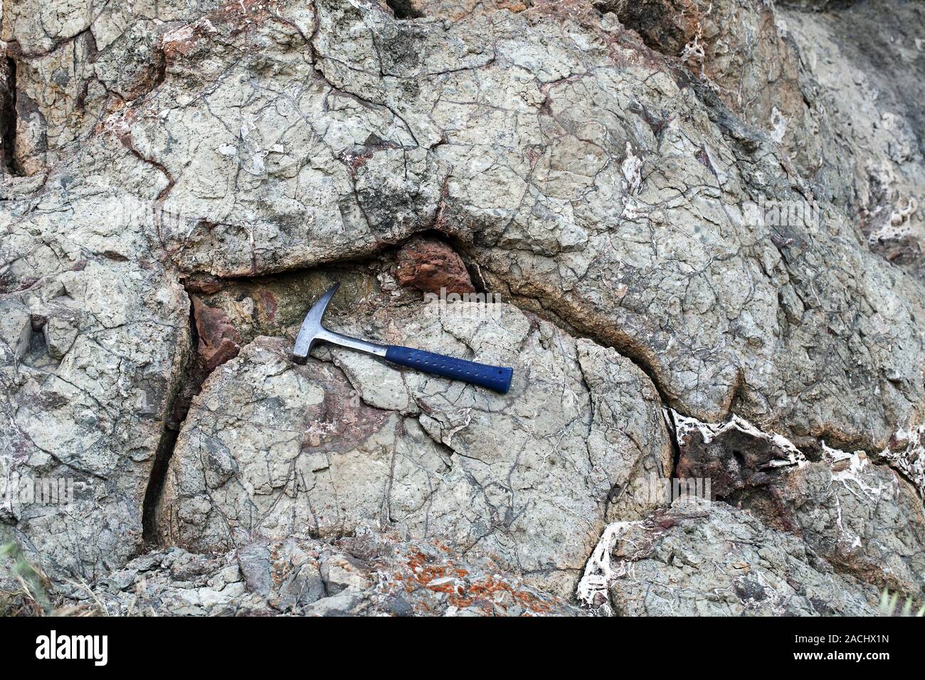 Pillow lava. Geological hammer (to show scale) on an outcrop of pillow ...