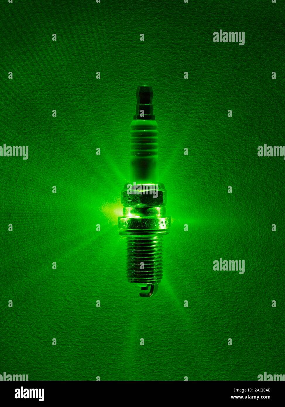 Spark plug lit with a green laser. This electrical device is used in ...
