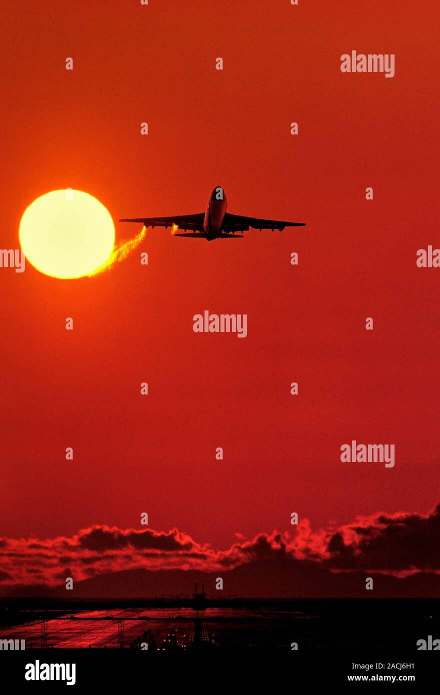 Boeing 747 taking off at sunset. The orange plumes behind the aircraft ...