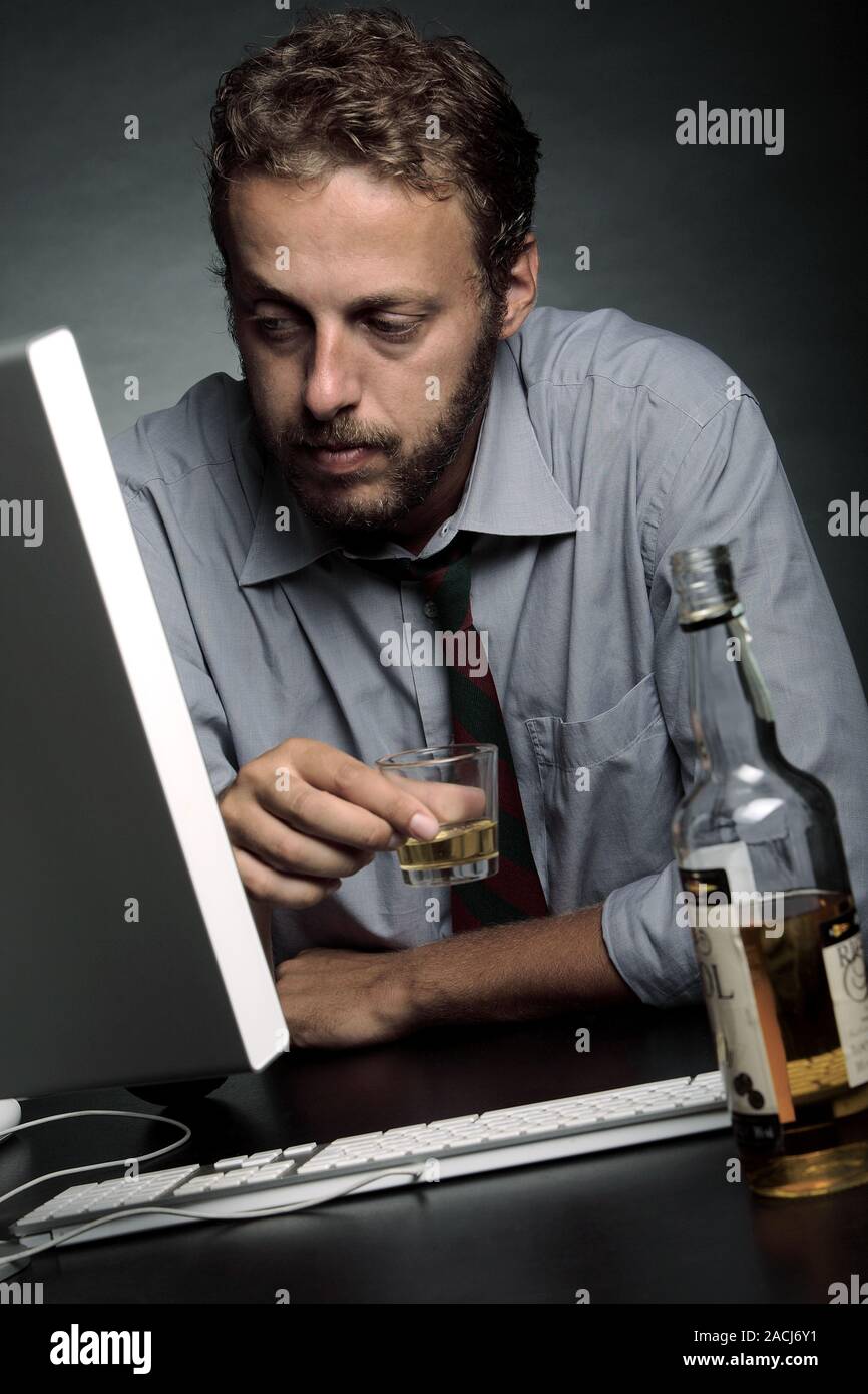 Work stress. Man drinking alcohol to help with stress while working at ...