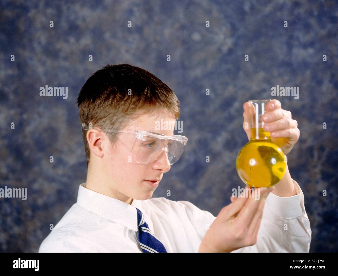 Potassium chromate solution. Schoolboy holding up a round-bottomed ...