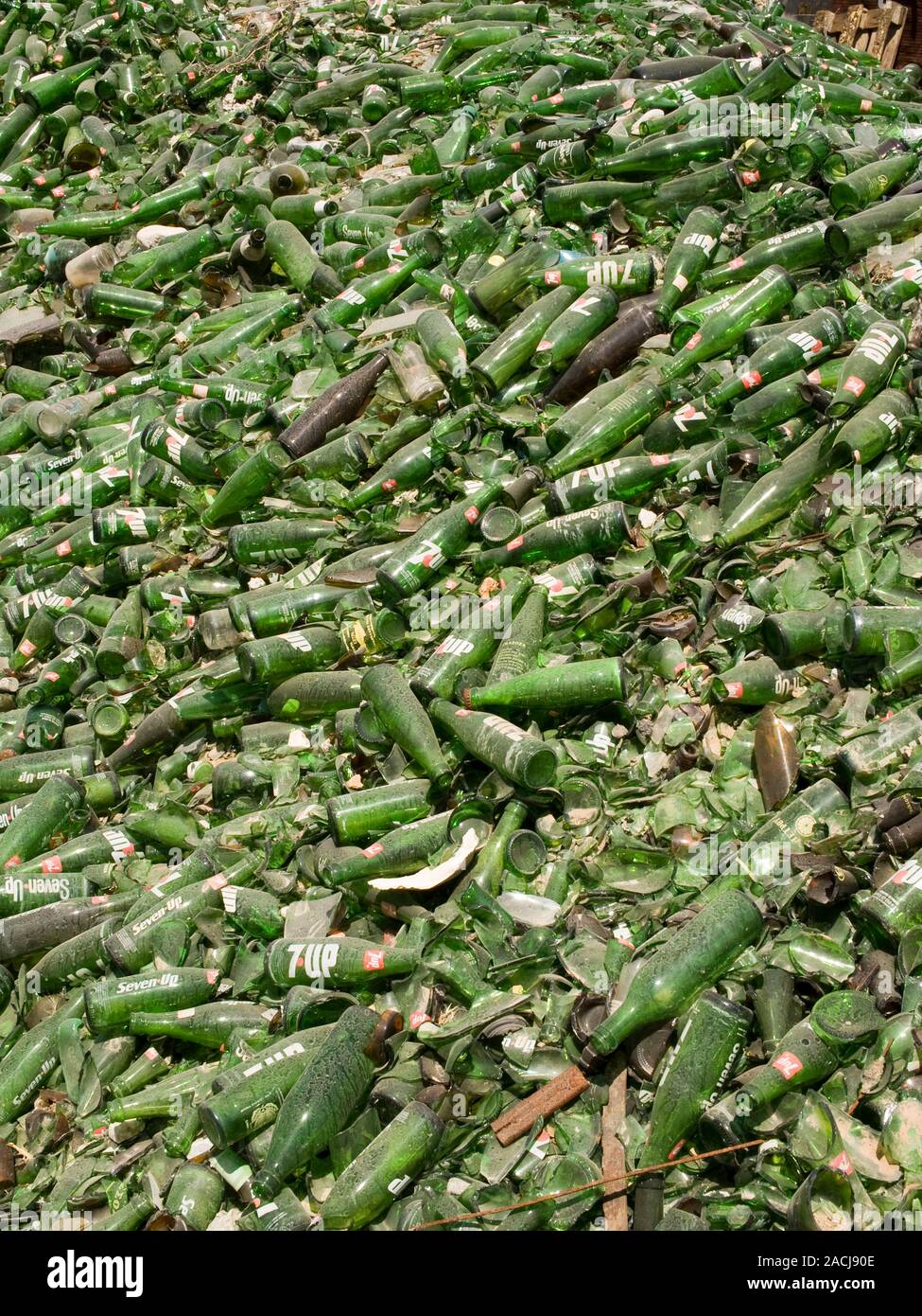 Used beverage bottles heaped behind a glass works in Crete for ...