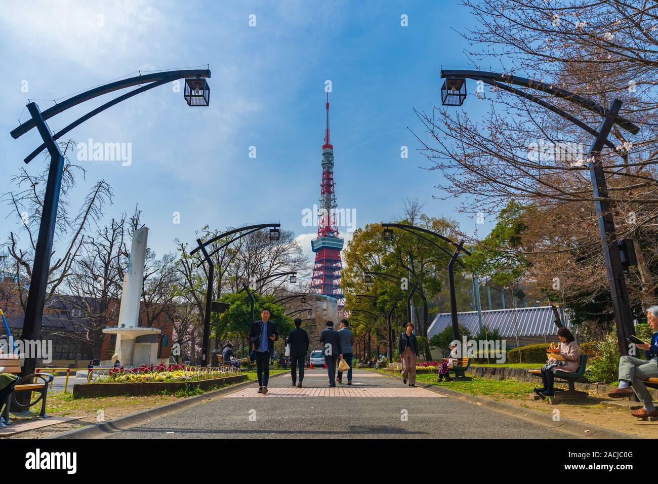 TOKYO, JAPAN - March 25, 2019: Unidentified people resting in the Shiba Park with Tokyo Tower ...