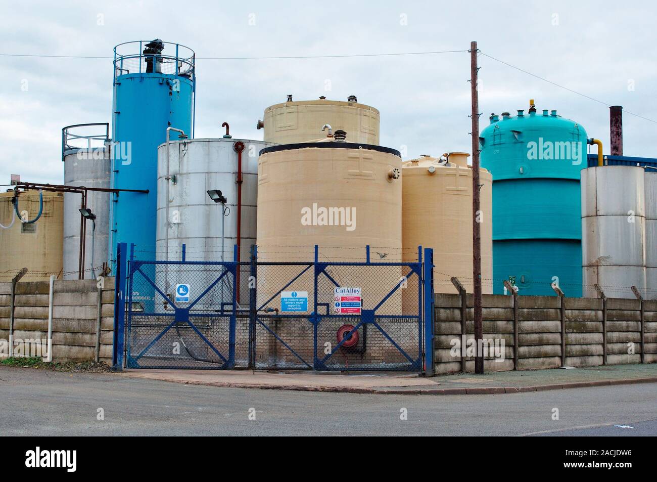 Chemical storage tanks. Large industrial chemical tanks, secured behind ...