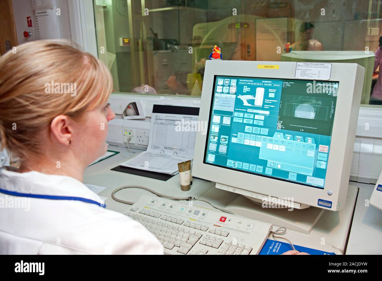 CT scan. Radiographer in the control room of a CT (computed tomography ...