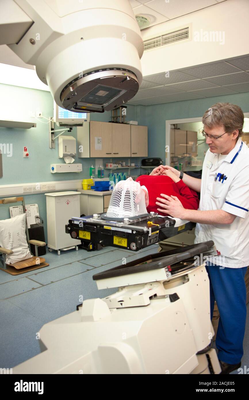 Radiotherapy simulator. Patient being lined up on an X-ray machine used ...