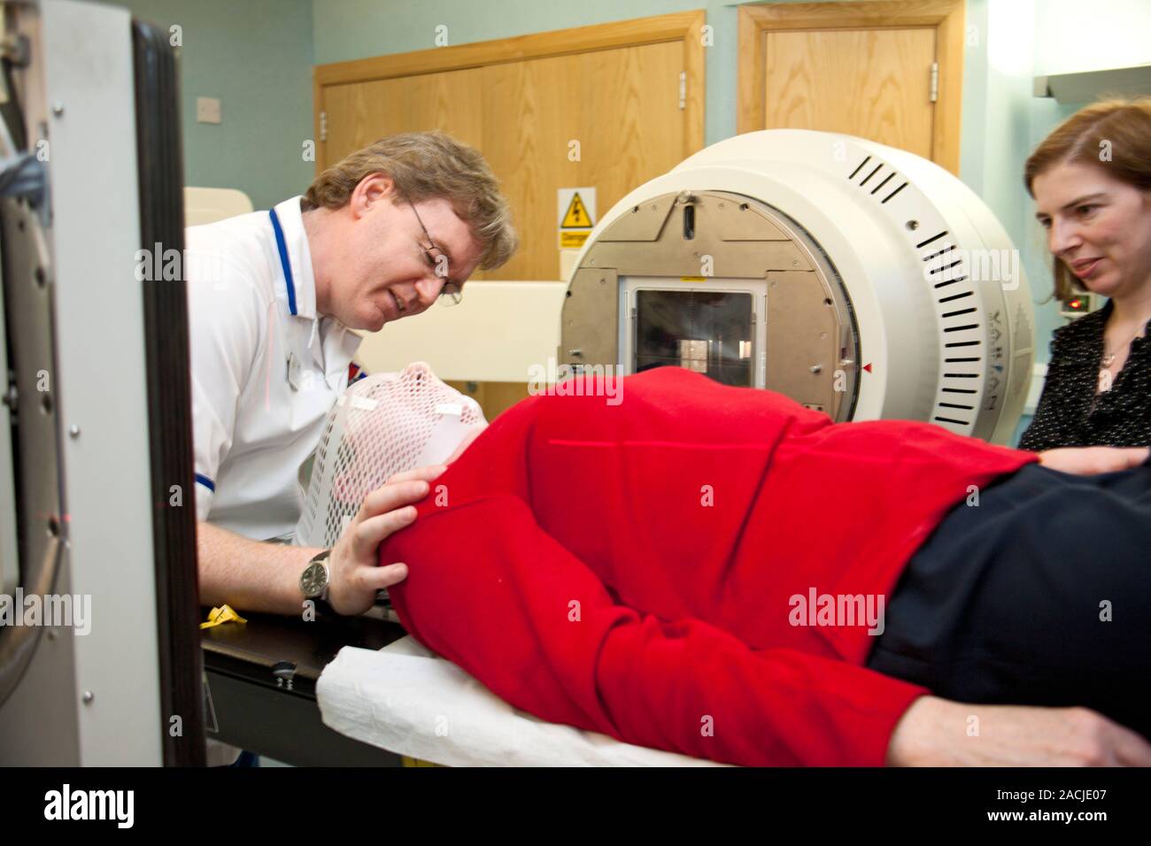Radiotherapy simulator. Patient being lined up on an X-ray machine used ...