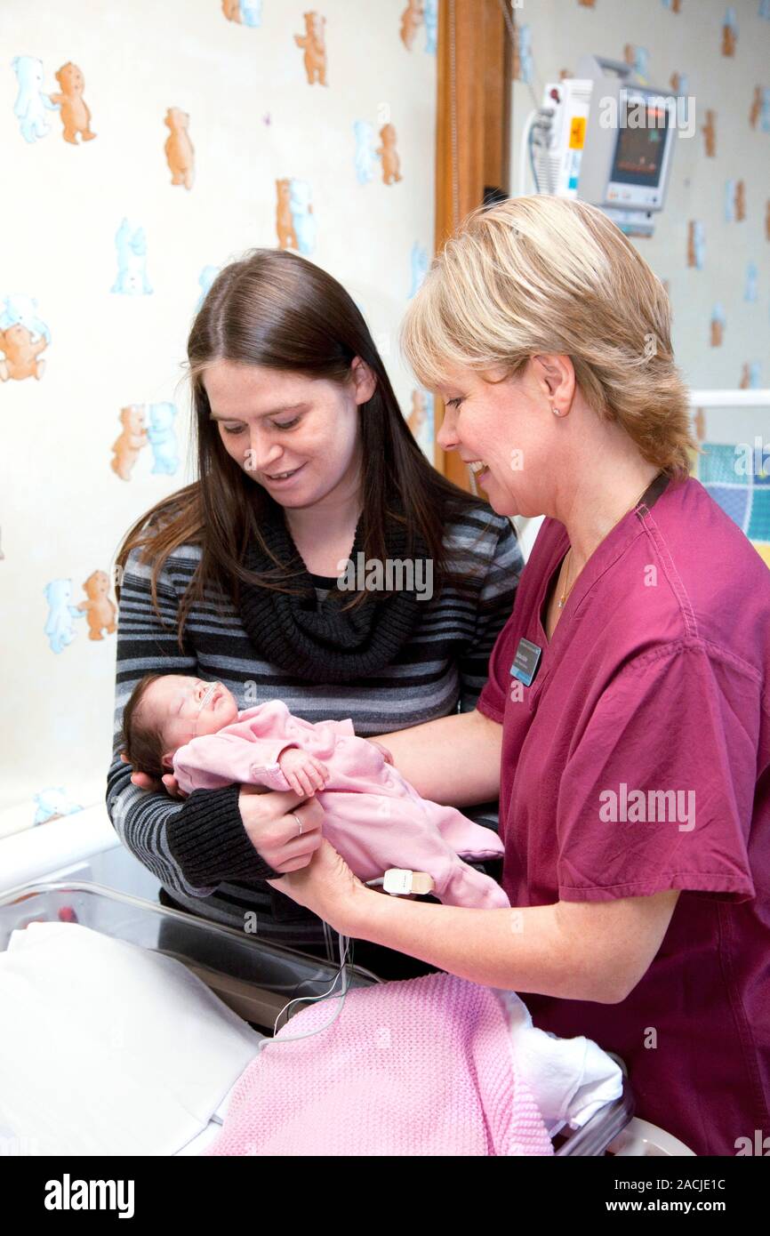 Mother, nurse and newborn baby. The baby is being cared for in a ...