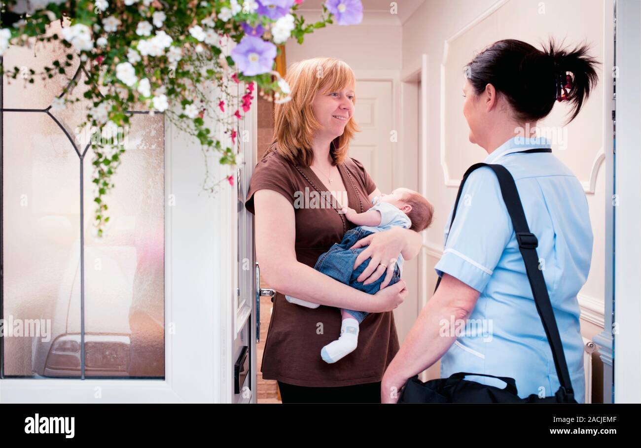 Midwife home visit. Midwife visiting a mother and her newborn child at ...