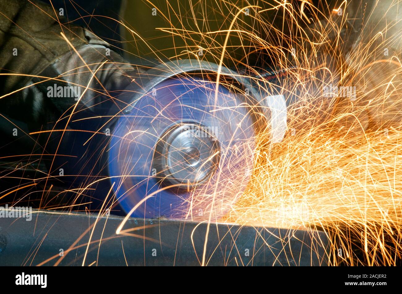 Metal working. Metalworker using an angle grinder in an engineering ...