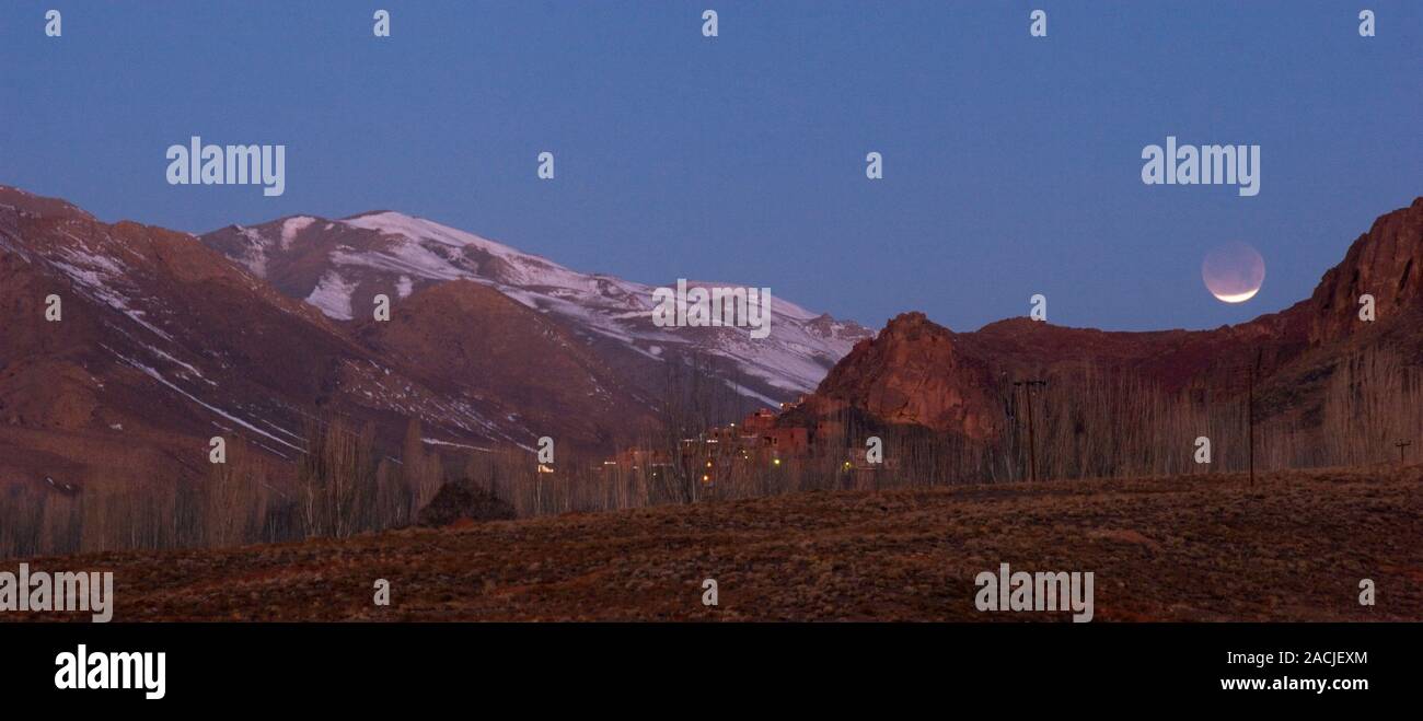 A landscape view of a deep partial lunar eclipse, captured moments ...