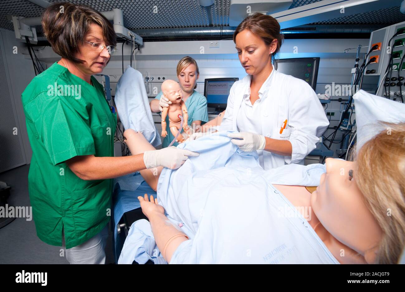 Childbirth simulation. Student midwife delivering a baby mannequin from ...