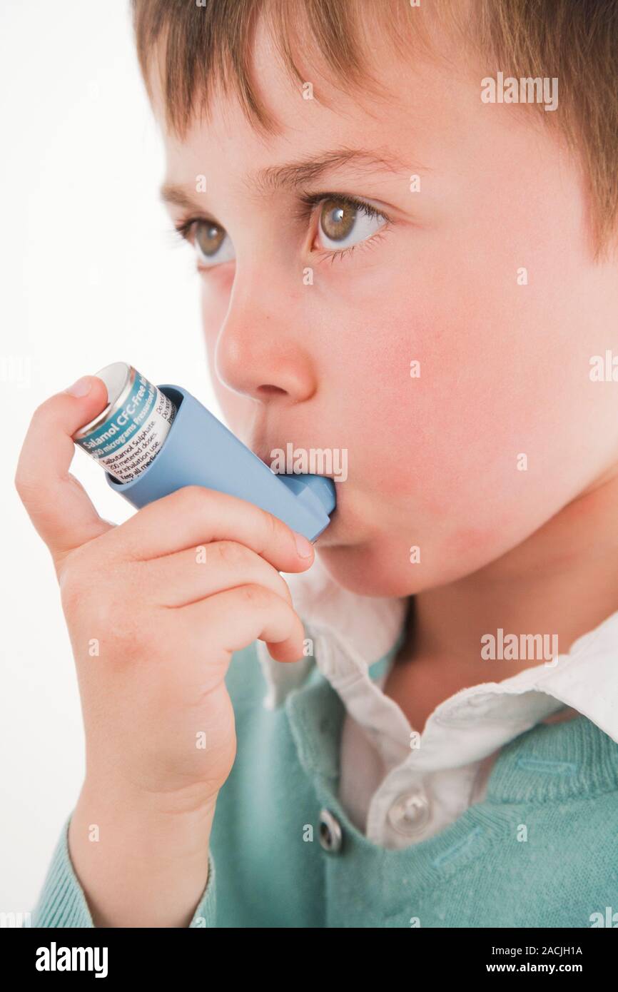 A five year old boy using an inhaler to treat an asthma attack. Asthma ...