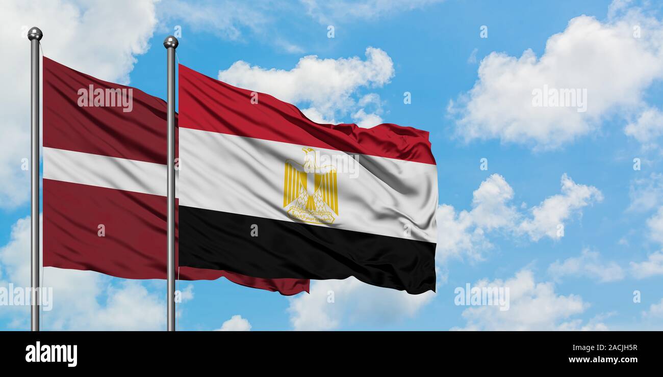 Latvia and Egypt flag waving in the wind against white cloudy blue sky ...