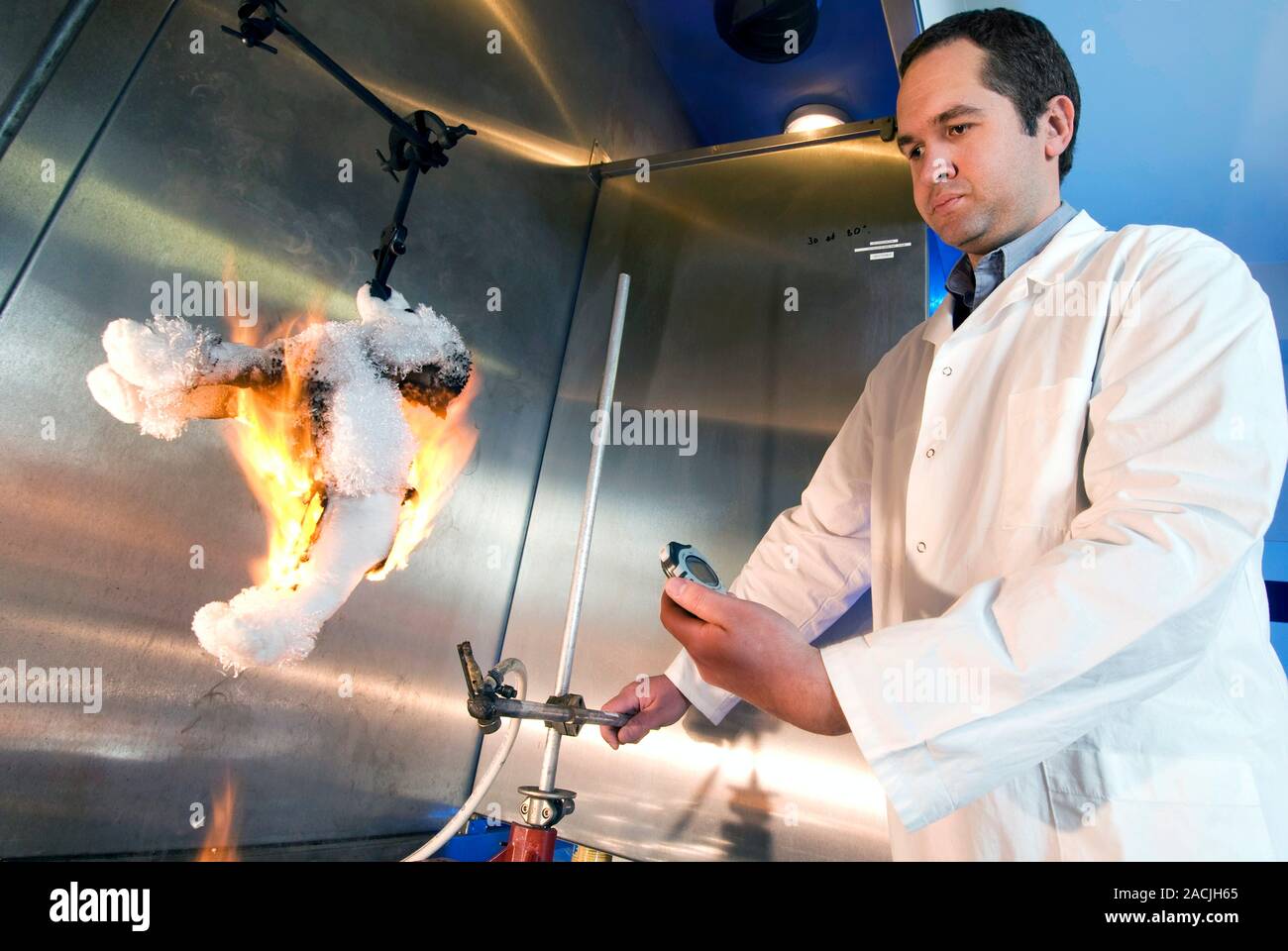 Product safety testing. Technician testing the flammability and flame ...