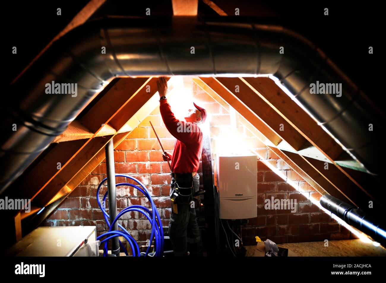 Domestic ventilation system. Engineer fitting a controlled ventilation ...